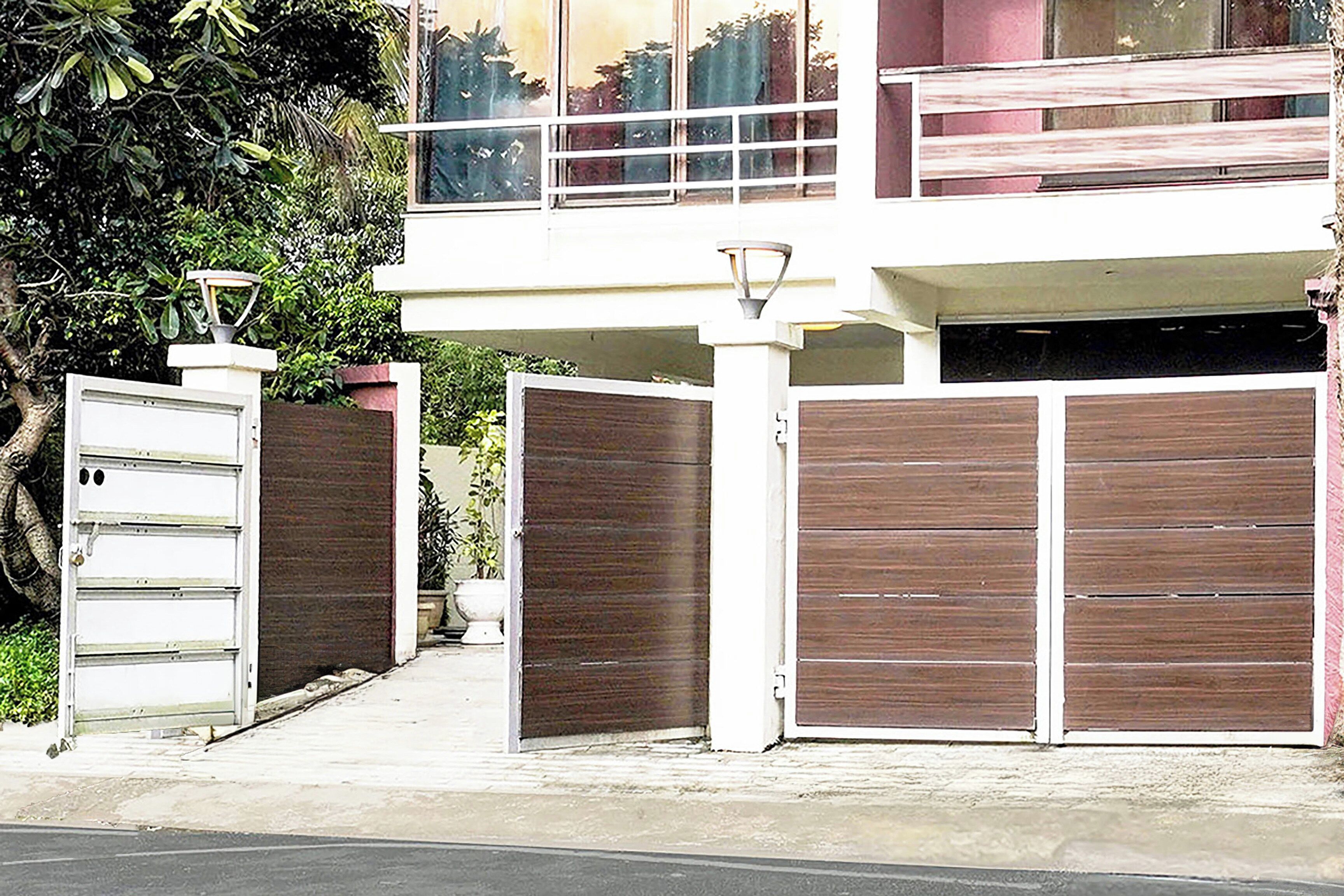 Um edifício de dois andares com portão fechado, garagem e varanda.