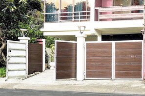 Um edifício de dois andares com portão fechado, garagem e varanda.