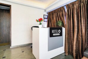 Balcão de recepção de hotel com placa indicando serviço empresarial.