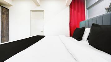 Quarto moderno com uma cama grande, cortina vermelha e cabeceira cinza.