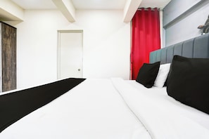 Quarto moderno com uma cama grande, cortina vermelha e cabeceira cinza.
