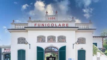 Um edifício com uma placa indicando 'FUNICOLARE' e o ano '1898' acima da entrada.