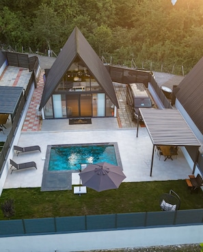 Uma casa moderna com piscina, área de estar externa e quintal cercado.