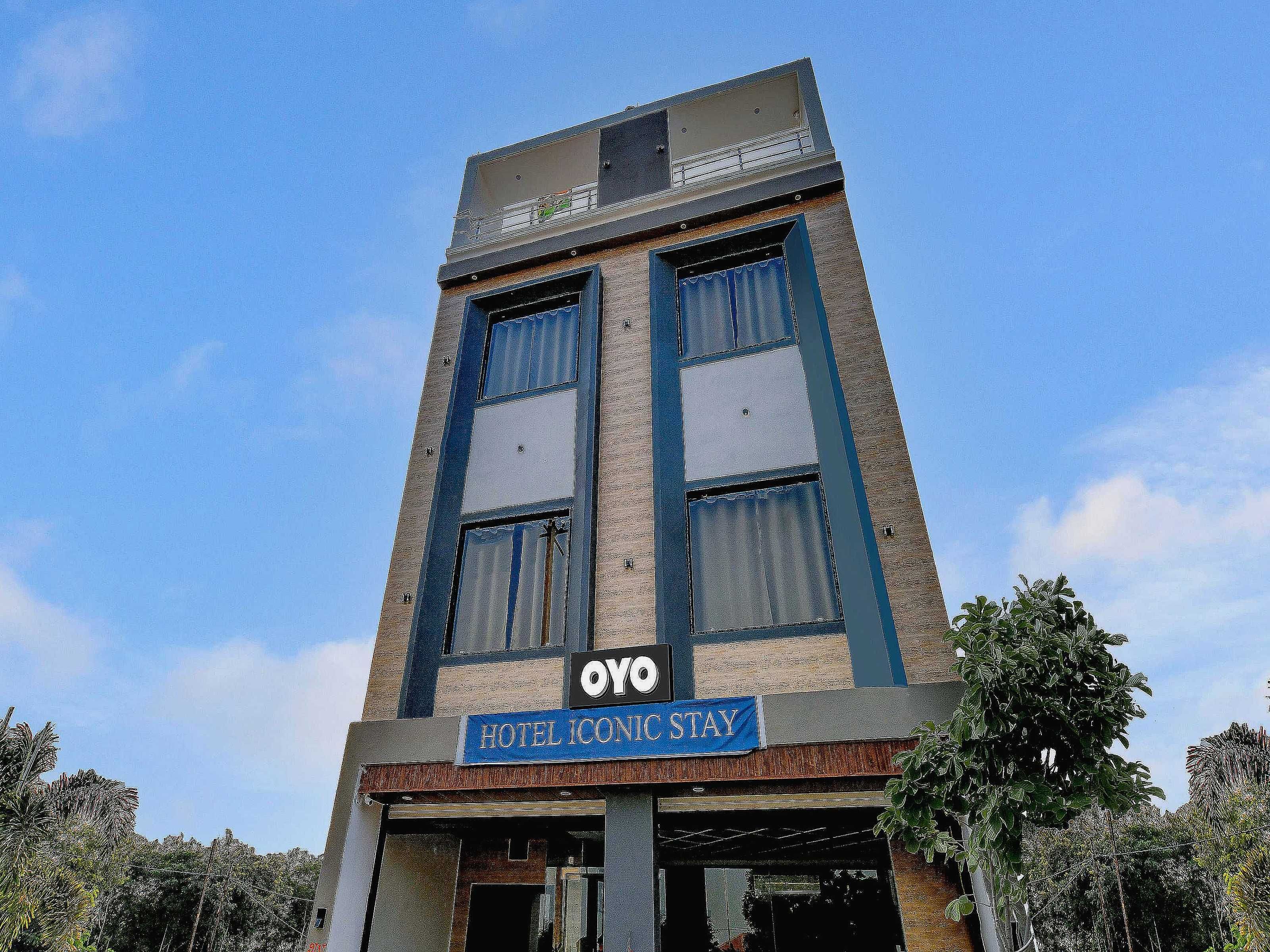 Edifício de hotel com uma placa exibindo 'HOTEL ICONIC STAY' e o logotipo 'OYO'.