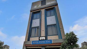 Edifício de hotel com uma placa exibindo 'HOTEL ICONIC STAY' e o logotipo 'OYO'.