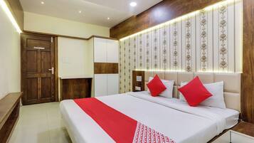 Quarto de hotel com uma cama grande, um guarda-roupa de madeira e uma parede com painéis decorativos.