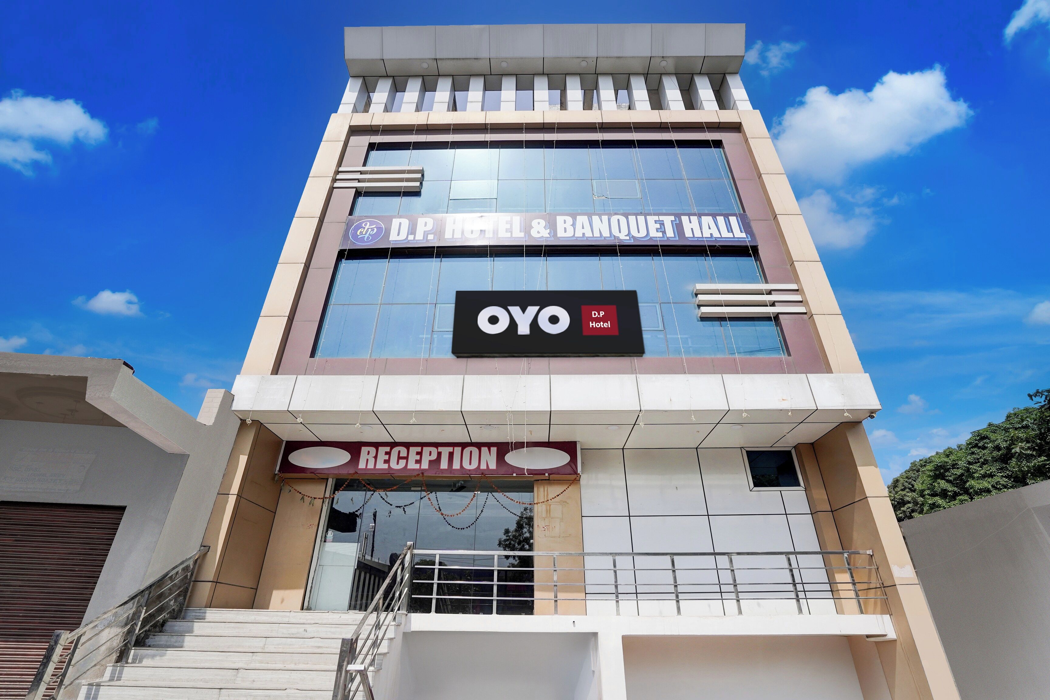 Um hotel com uma área de recepção e uma placa para D.P. Hotel & Banquet Hall.