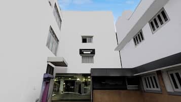 Um beco estreito entre dois edifícios brancos com uma placa indicando 'TOWNHOUSE'.