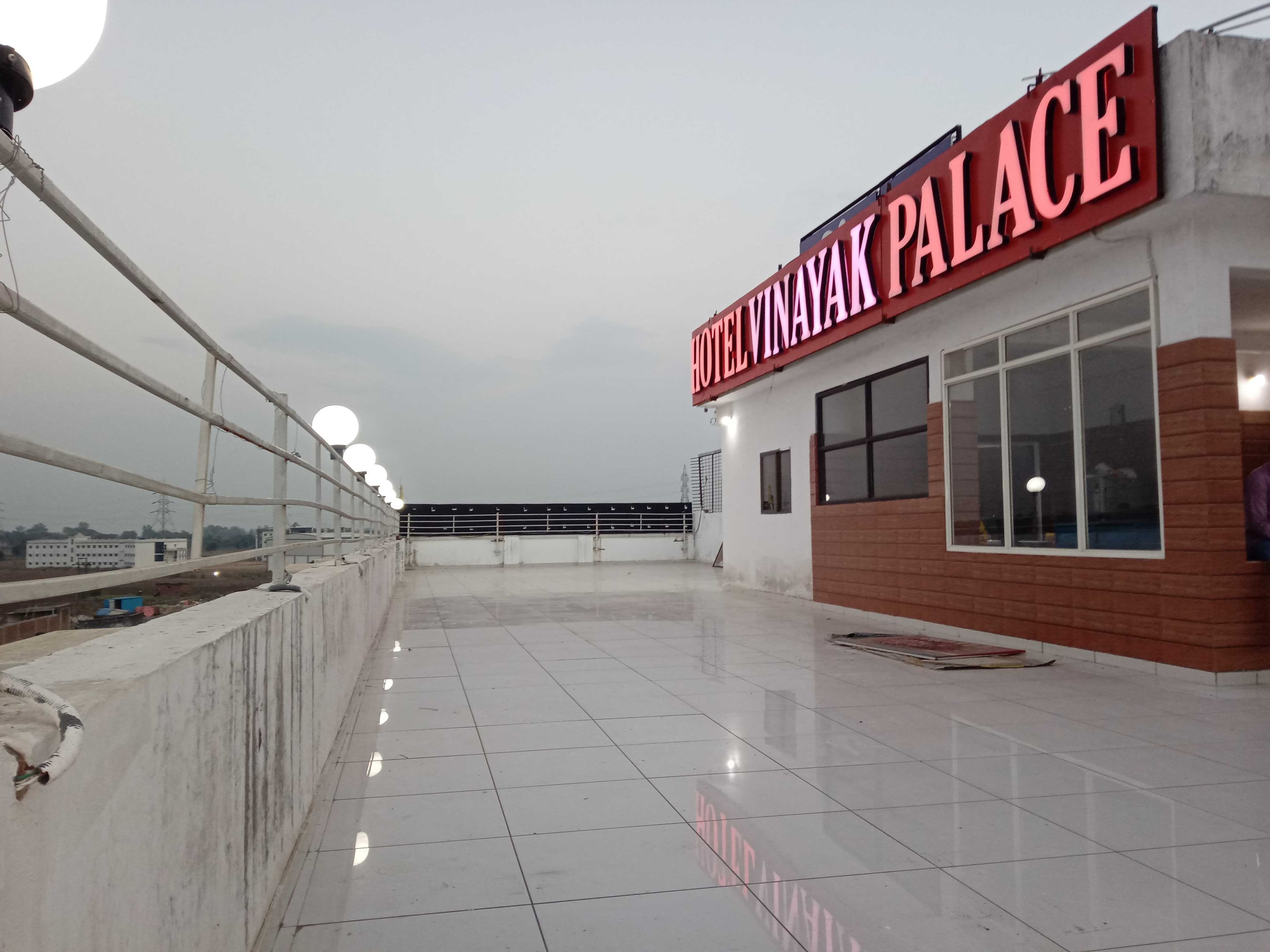 Um hotel chamado 'Hotel Vinayak Palace' com piso de azulejos e vista desobstruída da área ao redor.