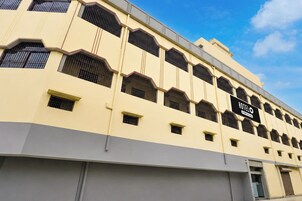Um edifício de hotel com várias janelas e uma placa indicando que é um hotel.