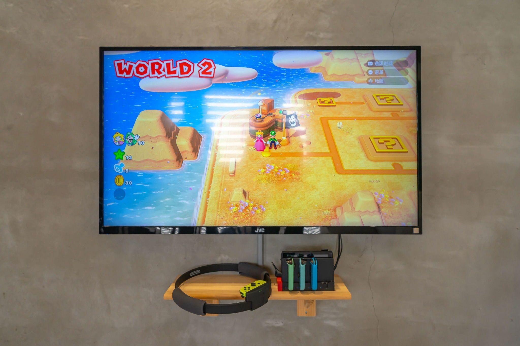 Uma televisão na parede exibe um jogo de vídeo intitulado 'WORLD 2'.