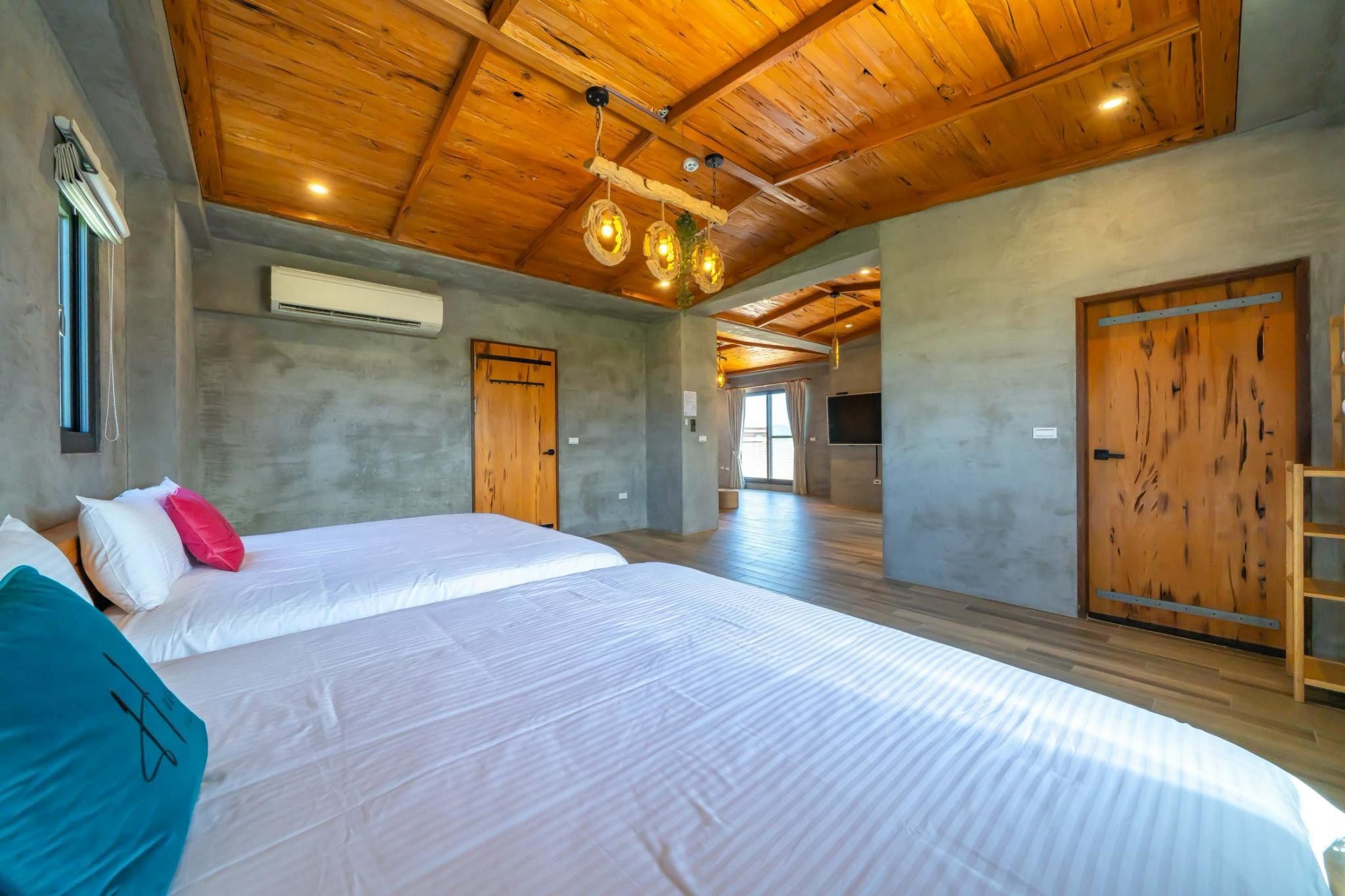 Quarto espaçoso com uma cama grande, teto de madeira e design moderno.