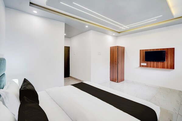 Quarto moderno com cama, guarda-roupa e televisão na parede.