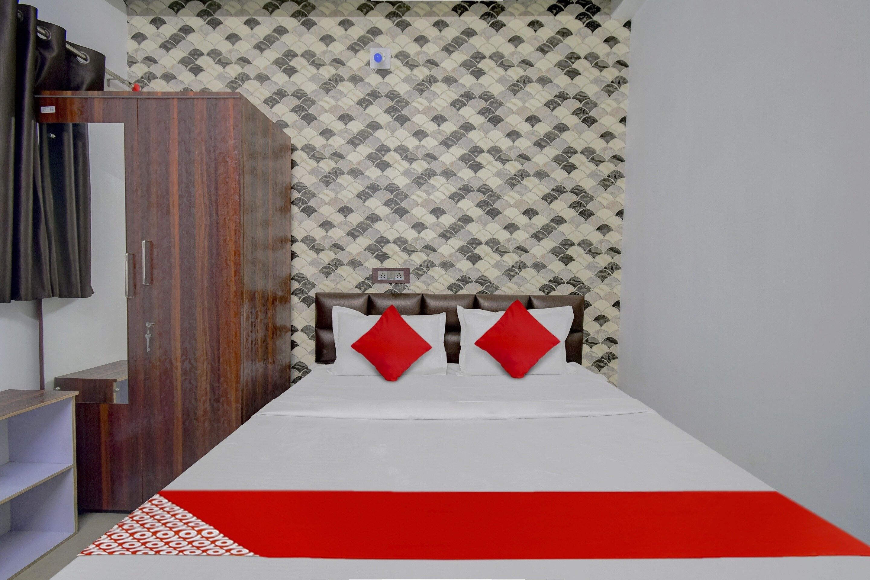 Quarto com cama, guarda-roupa e parede estampada.