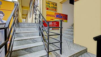 Escadaria que leva ao terceiro andar do Sai Teja College, com sinalização para Manappuram Gold Loan e Ria Money Transfer.