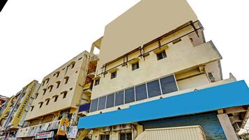 Edifício de vários andares com um hostel no andar térreo, várias janelas e uma cobertura azul.