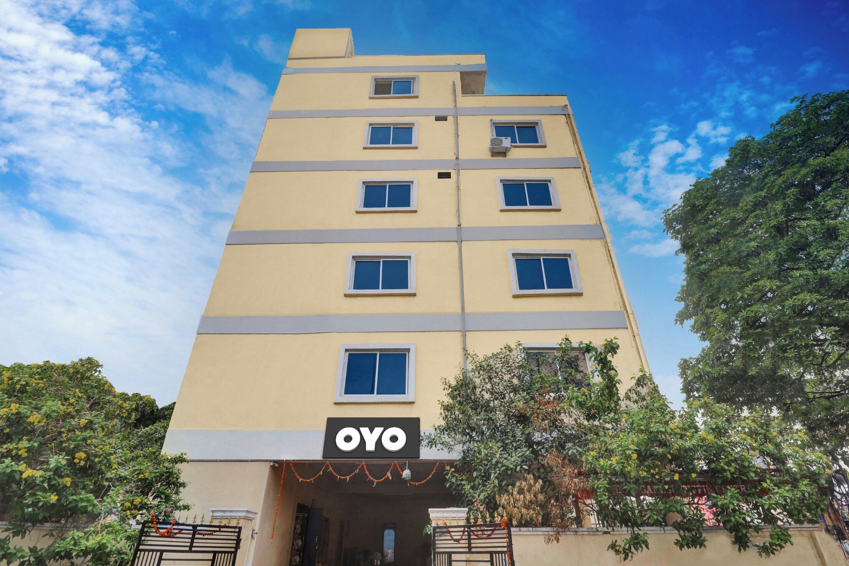 Edifício de vários andares com uma placa indicando 'OYO' na entrada.