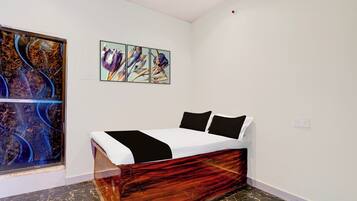 Quarto com cama, obra de arte na parede e piso de mármore.