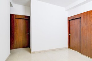 Corredor com duas portas de madeira, uma com a placa 305 e a outra com 301, dando acesso a quartos.