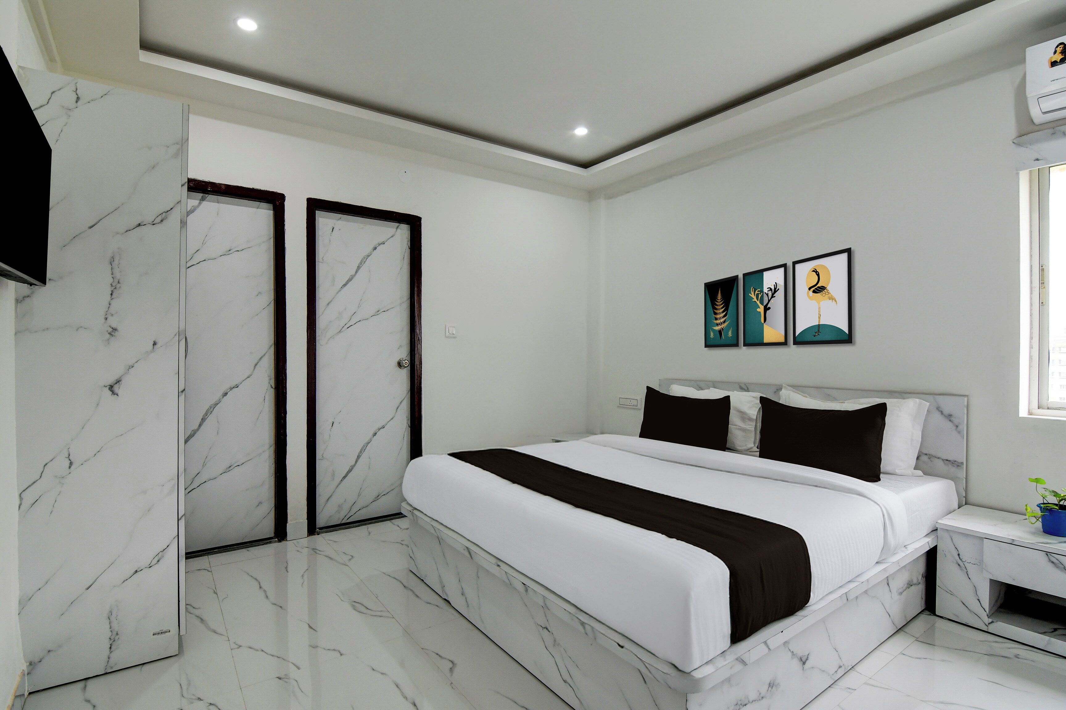 Quarto moderno com cama grande, guarda-roupa e mesa de cabeceira.