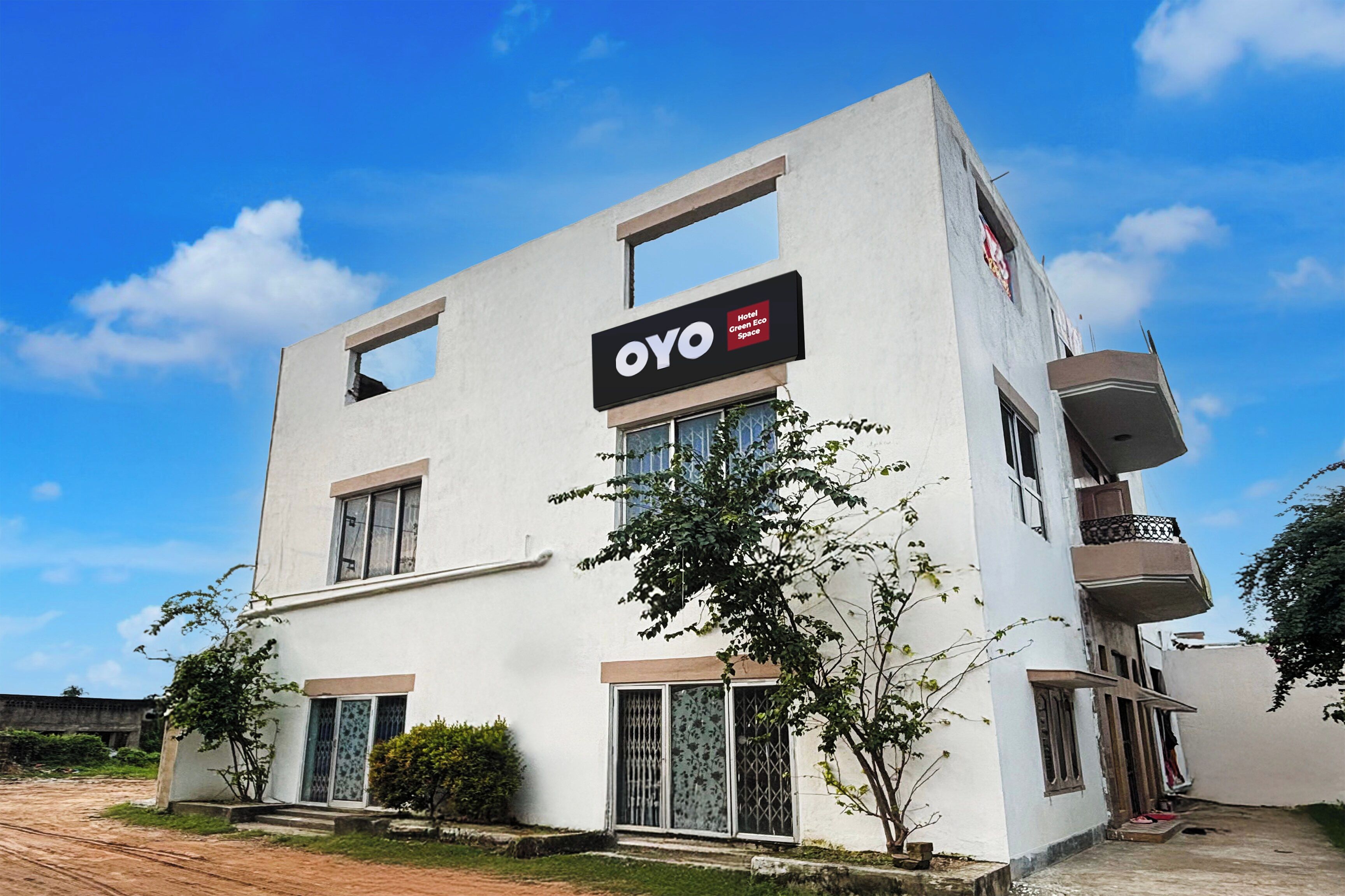 Um edifício de hotel moderno com uma placa indicando 'OYO Green Eco Space'.