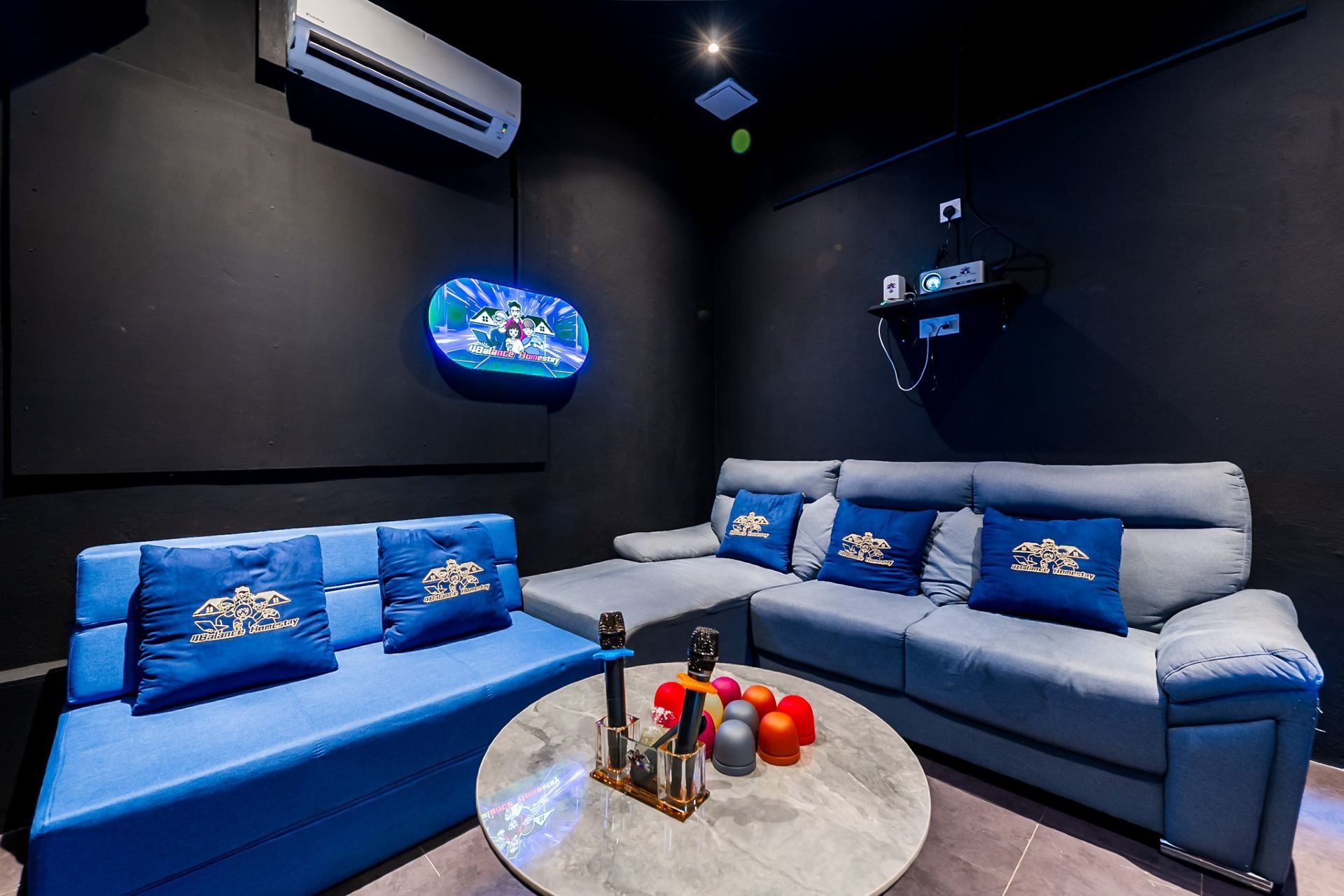 Um lounge moderno com sofá seccional e uma pequena mesa de centro, com o logotipo estampado nos assentos.