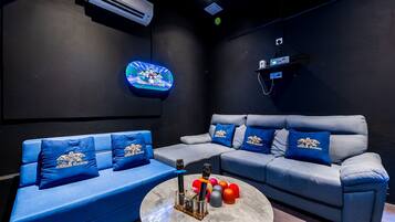 Um lounge moderno com sofá seccional e uma pequena mesa de centro, com o logotipo estampado nos assentos.