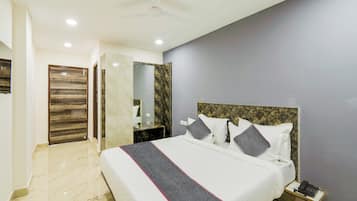 Quarto de hotel com cama grande, telefone ao lado da cama e piso de mármore.