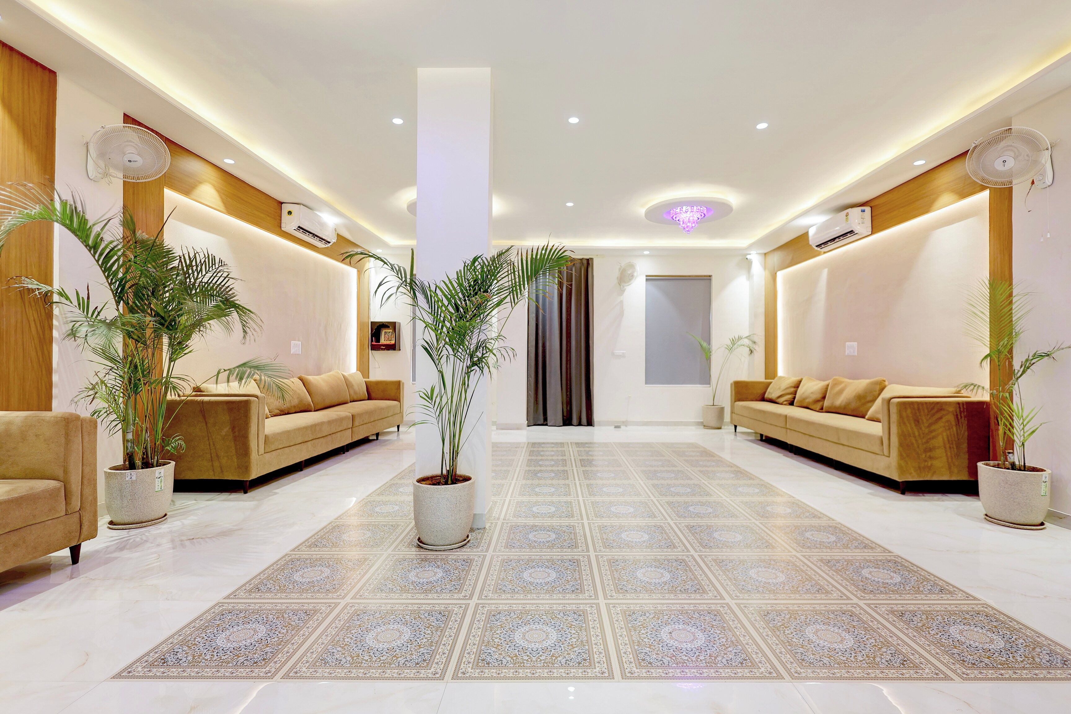 Sala de estar moderna com dois sofás, um pilar central e plantas em vasos.