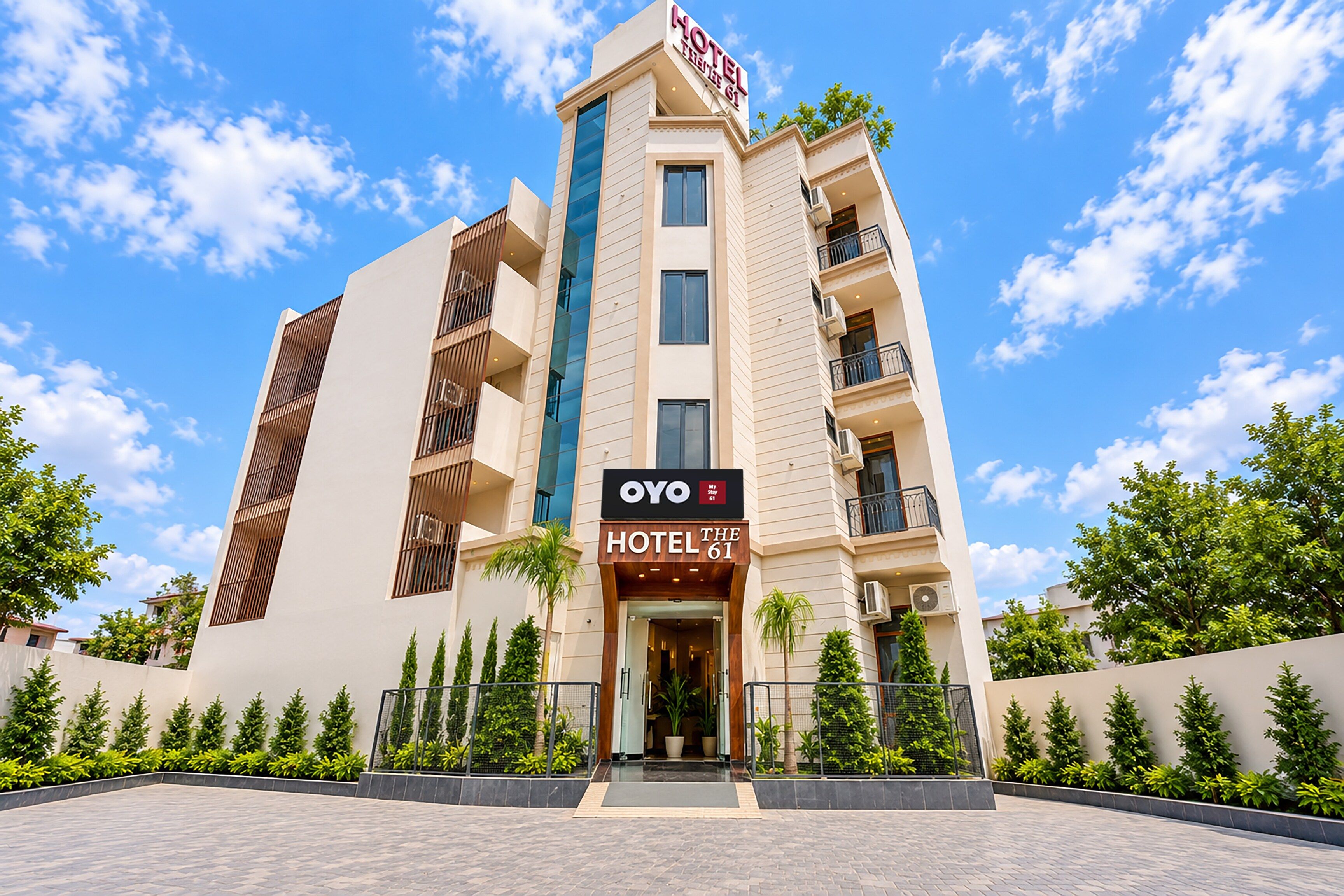 Um edifício de hotel moderno com uma placa de destaque que diz 'OYO HOTEL THE 61'.
