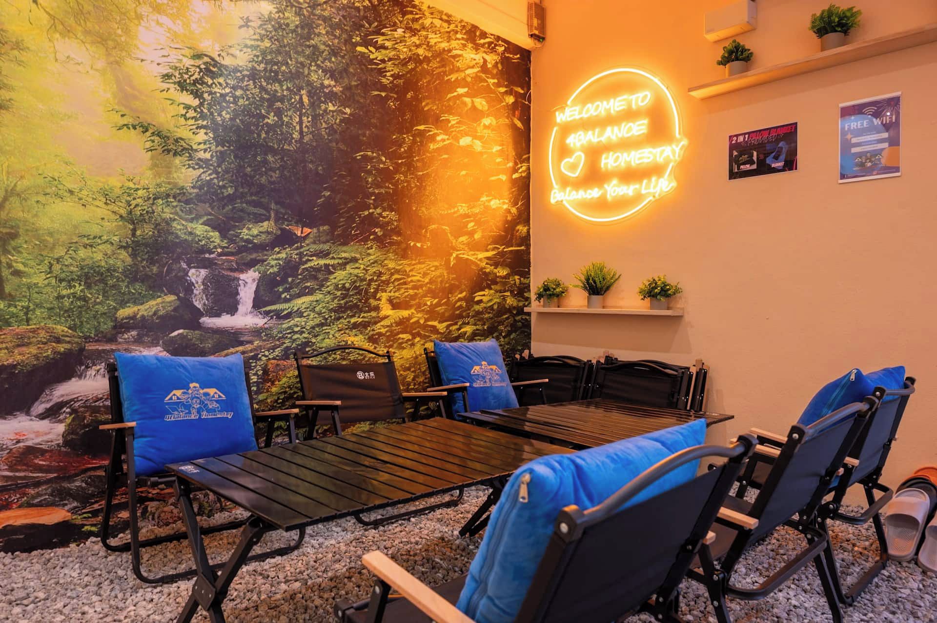 Quarto com painel de parede em cascata, letreiro de neon e mesa com cadeiras.