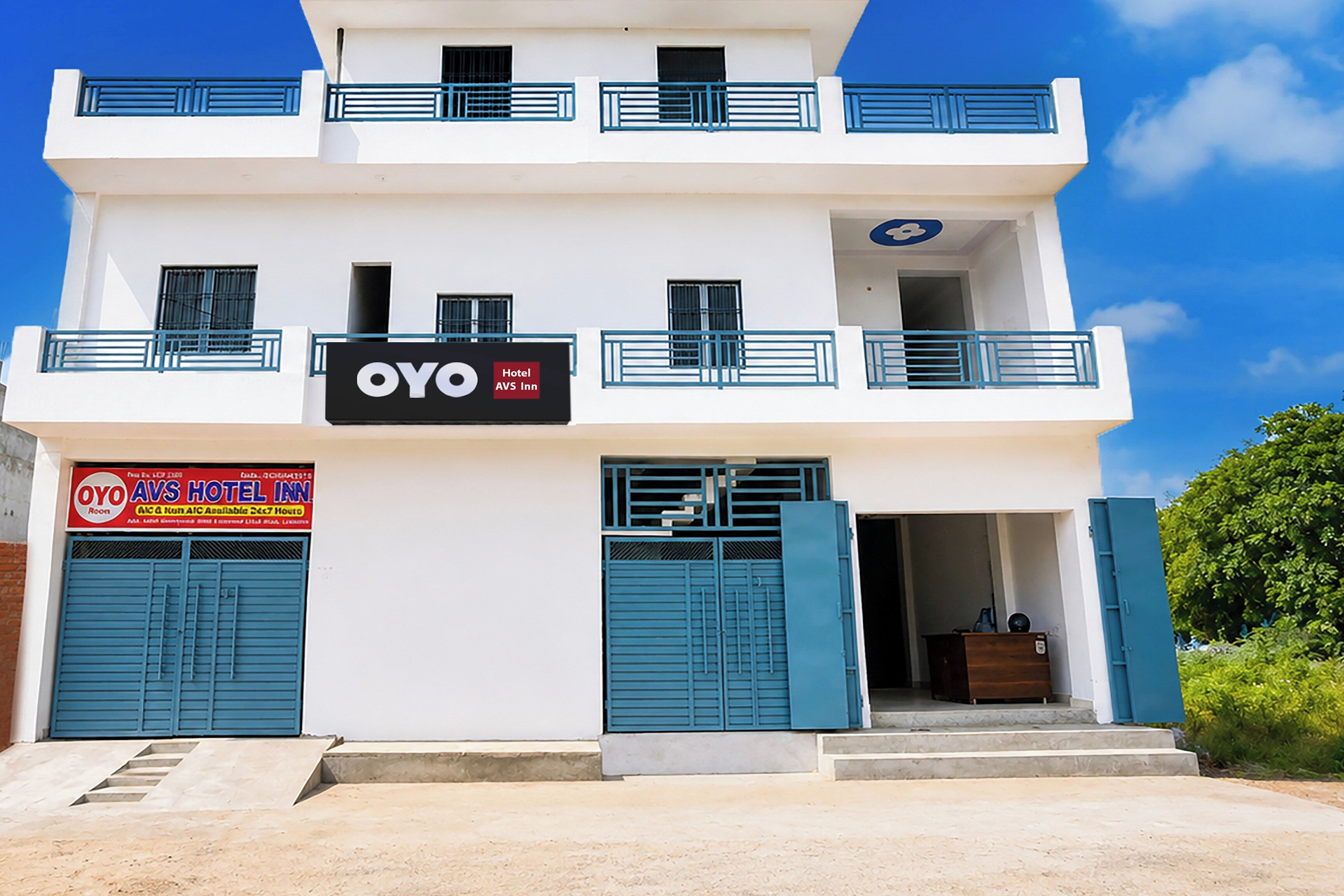 Um edifício de dois andares com uma placa indicando OYO AVS Hotel Inn.