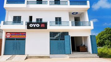 Um edifício de dois andares com uma placa indicando OYO AVS Hotel Inn.