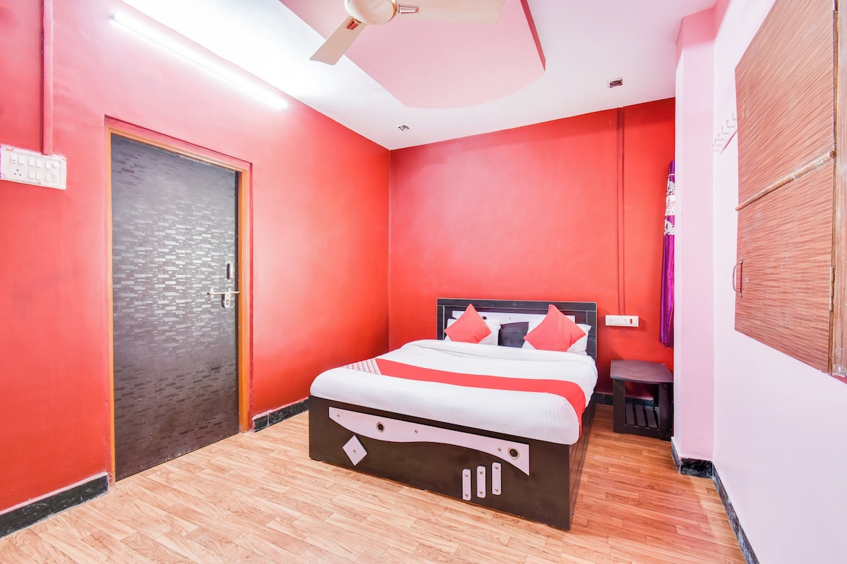 Quarto com cama, mesa de cabeceira, aquecedor fixado na parede e uma porta.