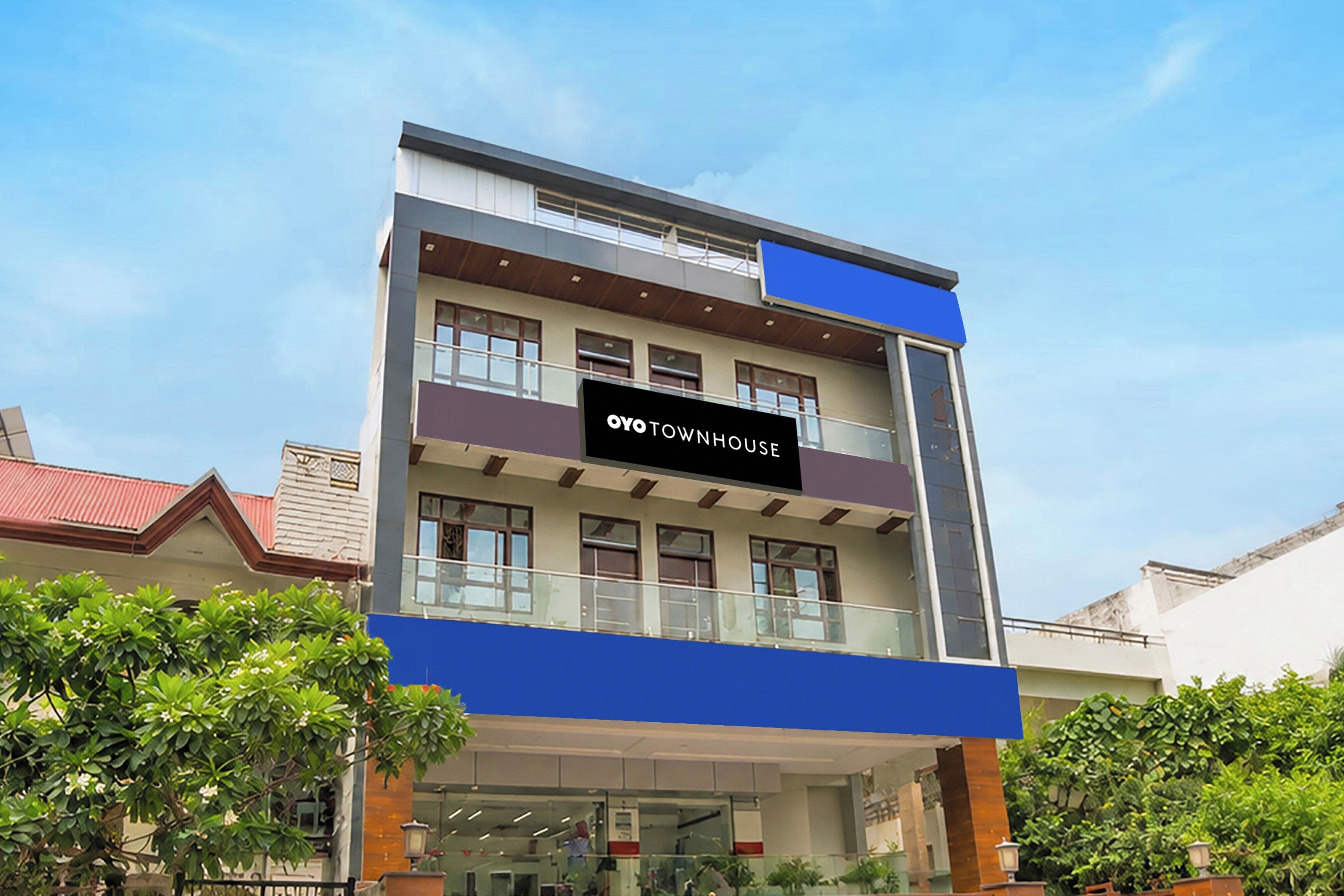 Um edifício de vários andares com uma placa que diz 'OYO TOWNHOUSE'.