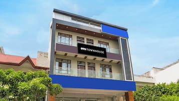 Um edifício de vários andares com uma placa que diz 'OYO TOWNHOUSE'.