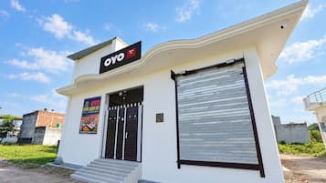 Um hotel chamado 'OYO' com design moderno, destacando uma entrada imponente e uma grande janela com persiana.