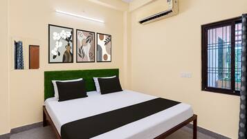 Quarto com cama, ar condicionado, obras de arte e janela com vista.