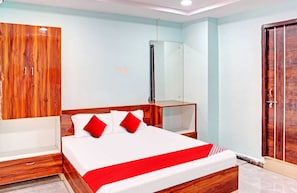 Quarto com cama, armário de madeira e espelho.