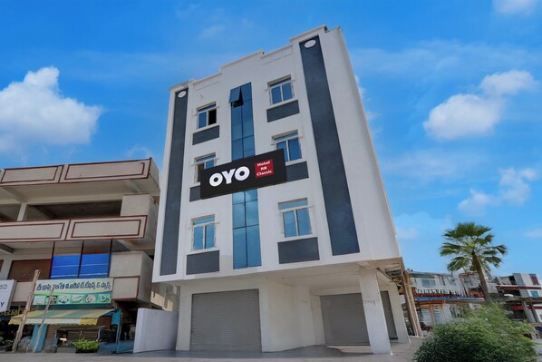 Edifício de um hotel com vários andares e um letreiro 'OYO' bem visível, indicando ser um hotel.