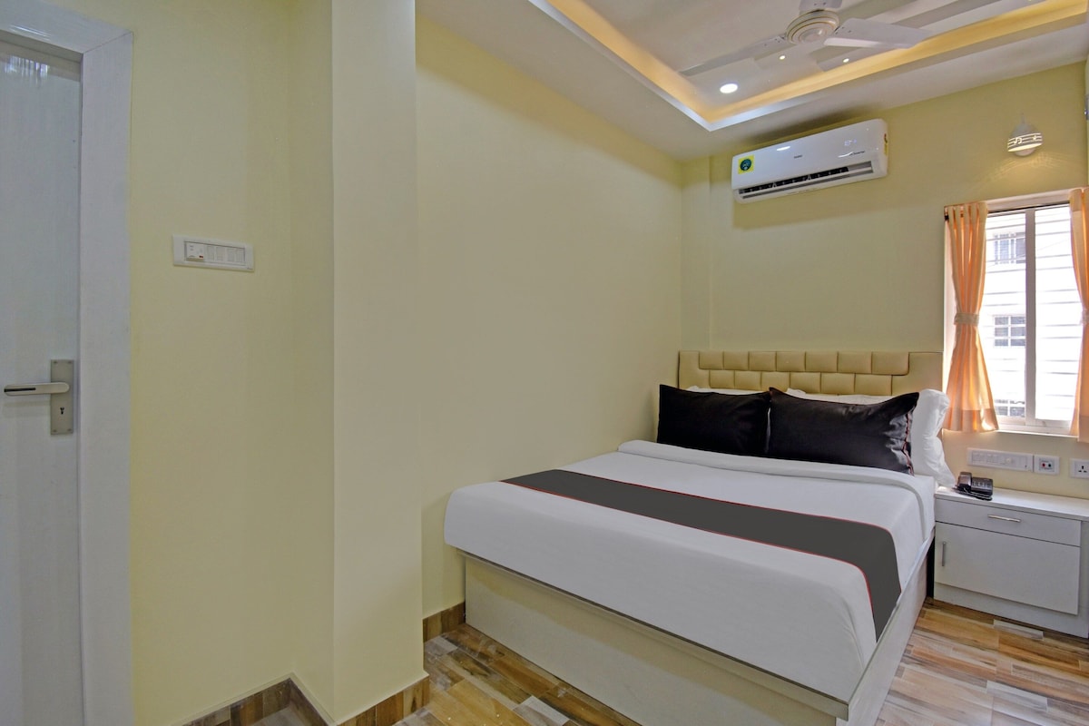 Quarto de hotel com cama, mesa de cabeceira e ar condicionado.