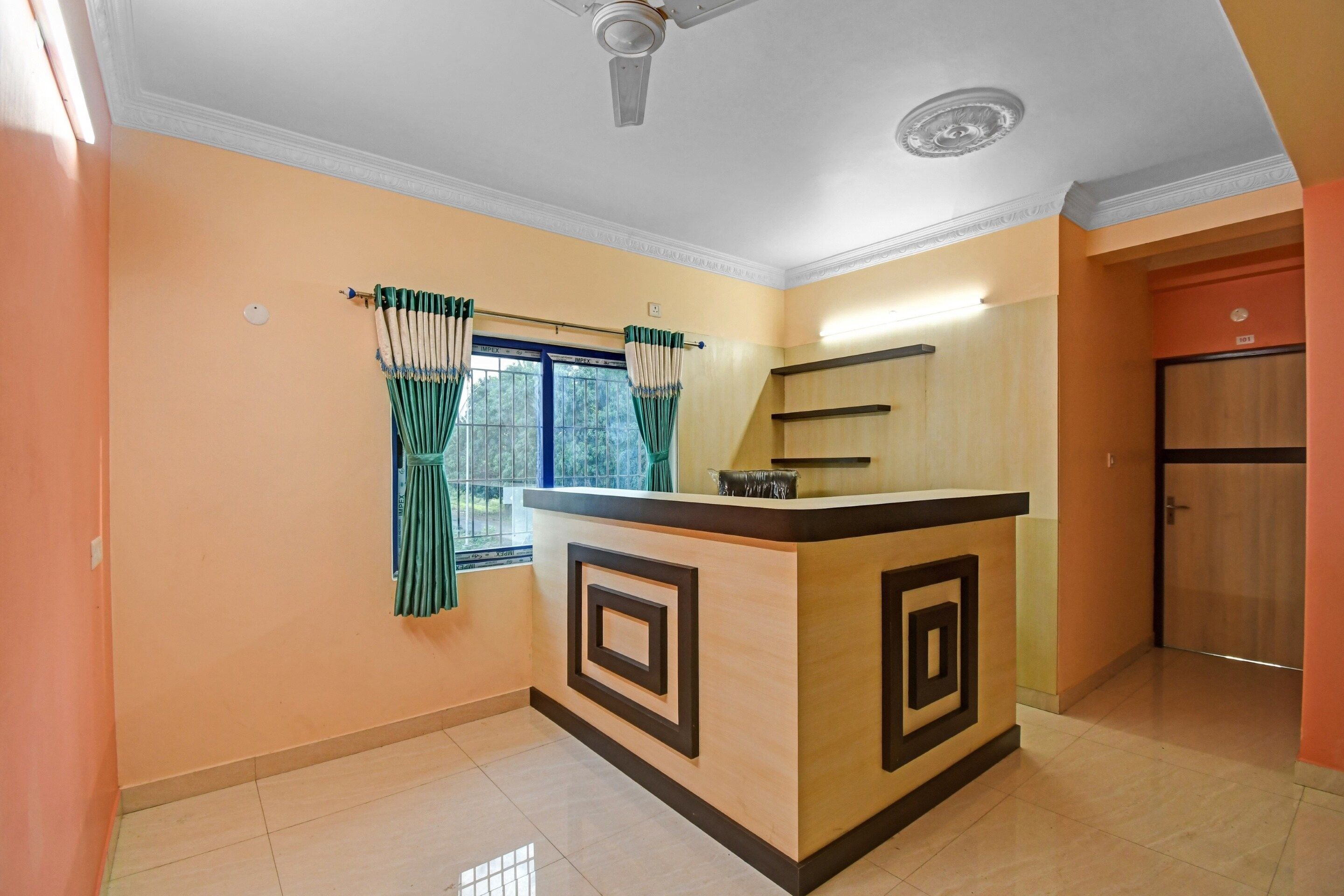 Cozinha com ilha central, janela com cortinas e ventilador de teto.