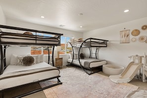 Quarto com beliche, tapete e decoração nas paredes.