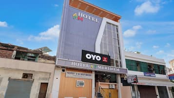 Um hotel com vários andares, com destaque para a placa que indica 'Hotel A.P. Meridian' e 'OYO Hotel'.