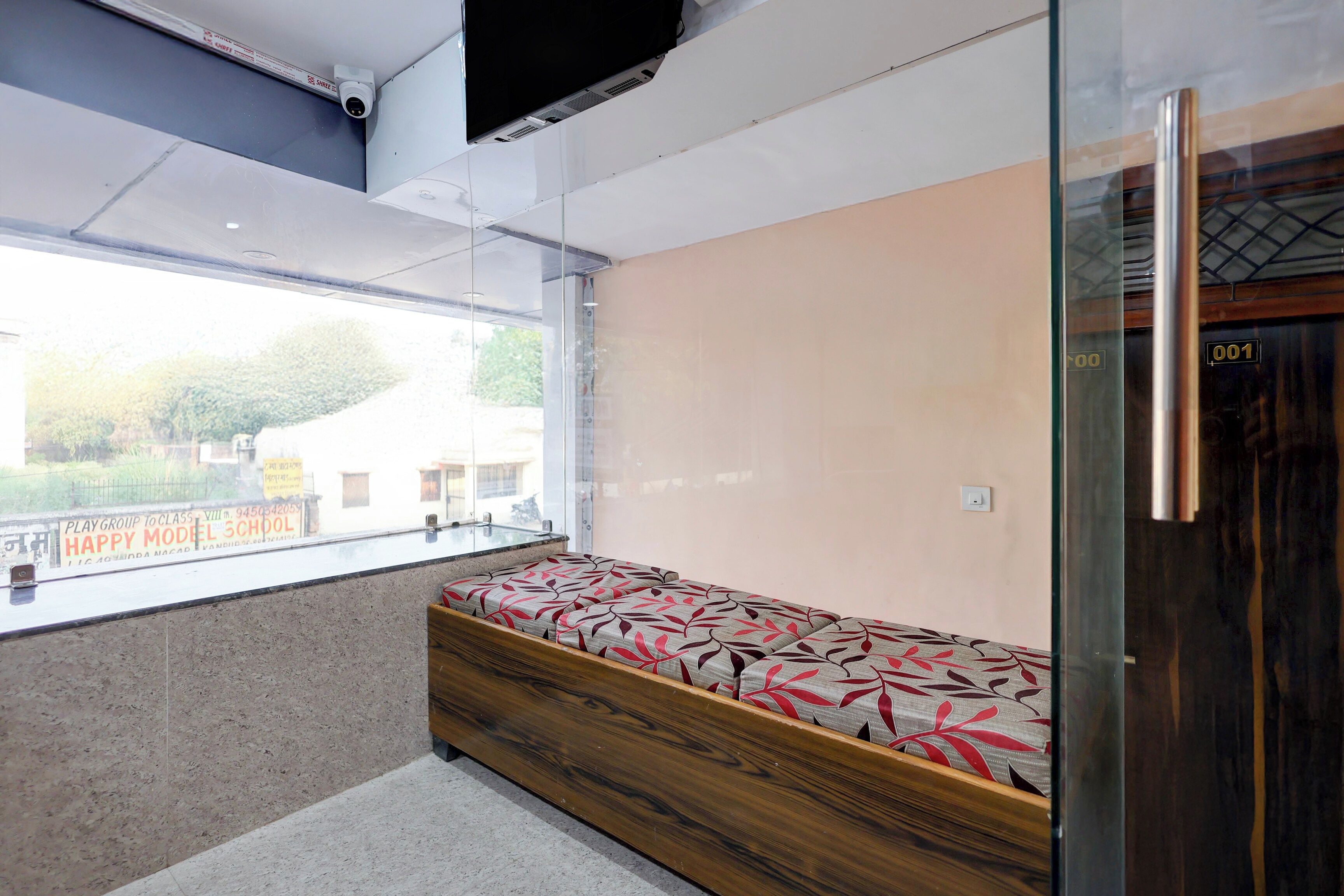 Quarto moderno com um banco, divisória de vidro e vista para o exterior.