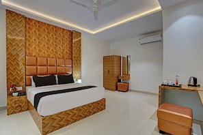 Quarto de hotel moderno com cama grande, escrivaninha, cadeira e guarda-roupa.