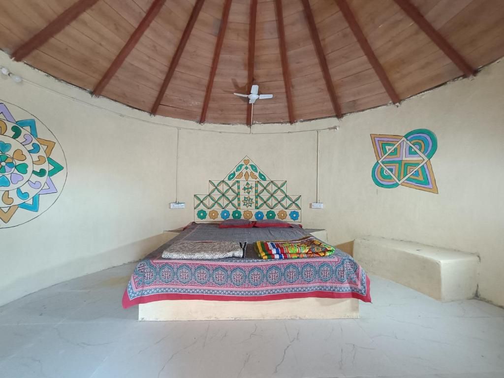 Quarto com cama, ventoinha no teto e detalhes decorativos nas paredes.