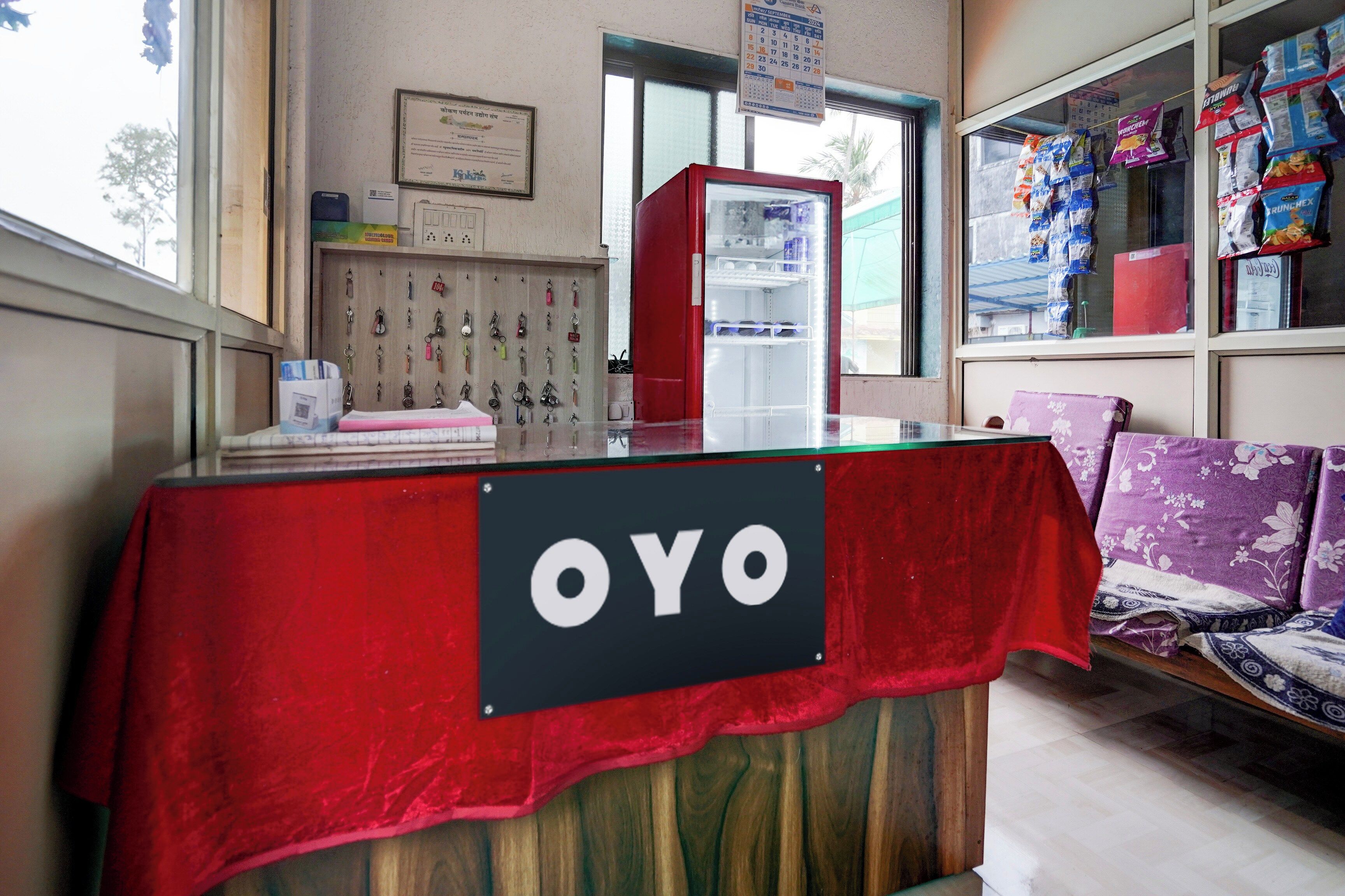Uma receção com um letreiro indicando 'OYO' e um calendário na parede.