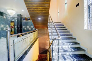 Uma escadaria com corrimão de madeira e degraus de mármore.