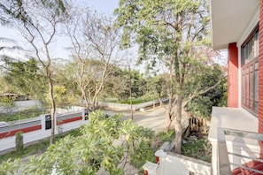 Área residencial com árvores, cerca branca e estrada.